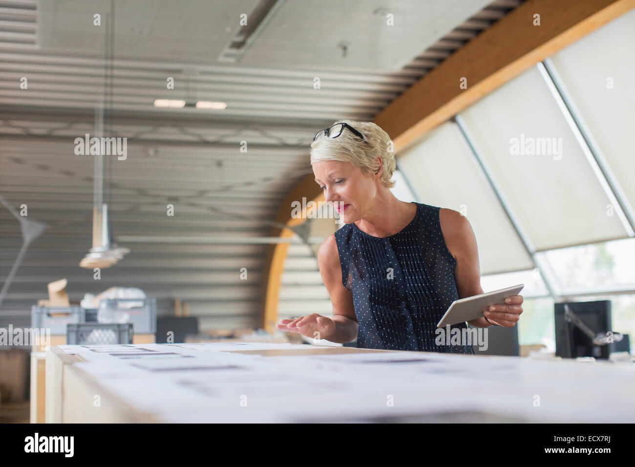 Businesswoman reading paperwork in office Stock Photo - Alamy