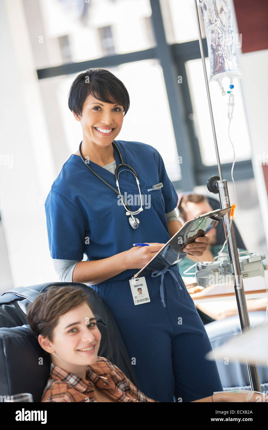Female doctor posing with young patient receiving medical treatment in ...