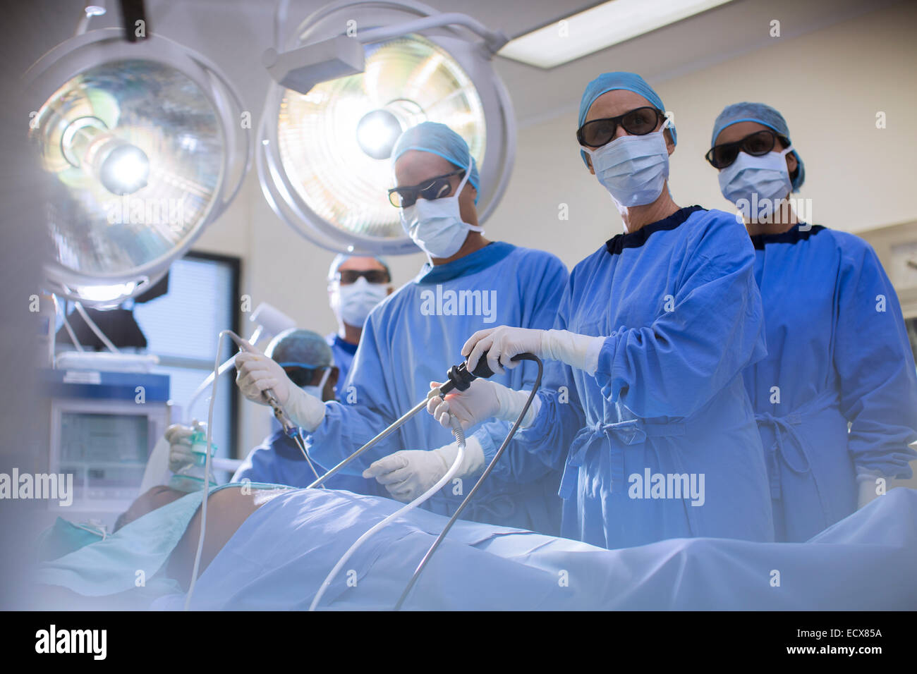 Team of doctors performing laparoscopic surgery in operating theater ...