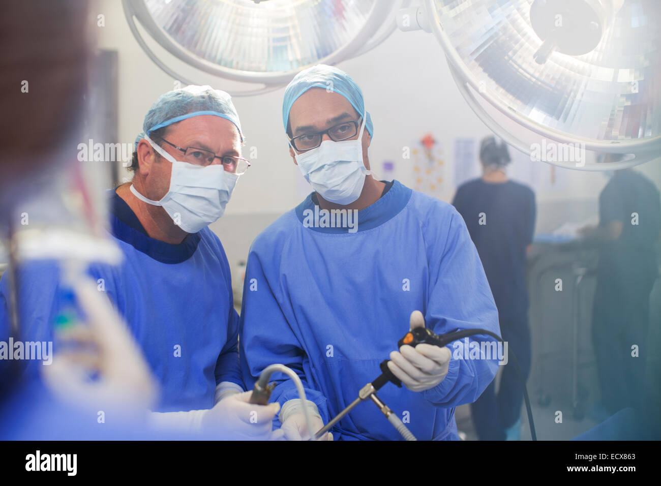 Portrait of doctors performing laparoscopic surgery in operating ...