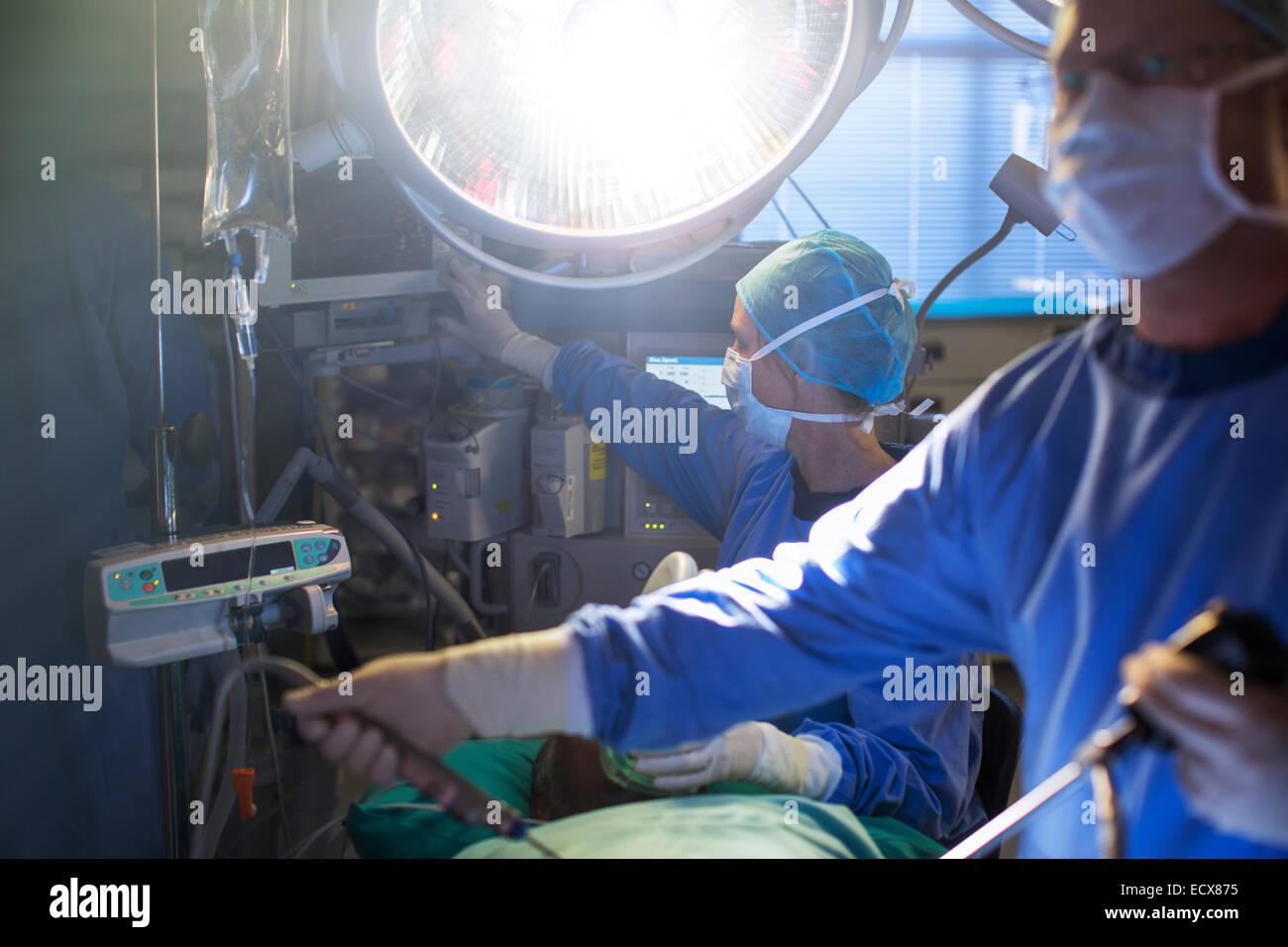 Male and female surgeons performing laparoscopic surgery in operation ...