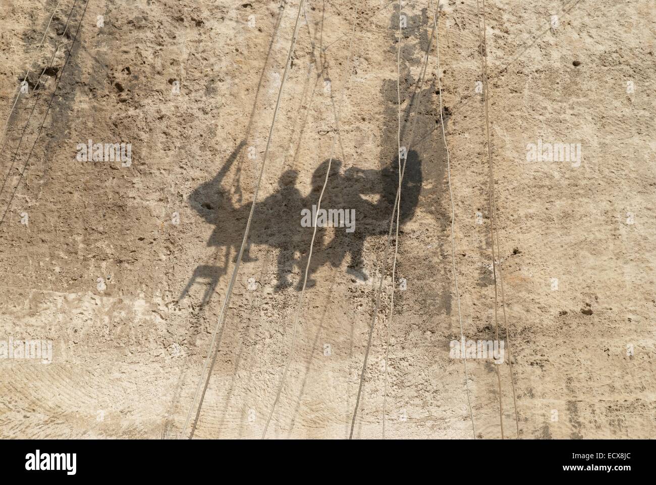 Human shadows on the bright yellow rock Stock Photo - Alamy