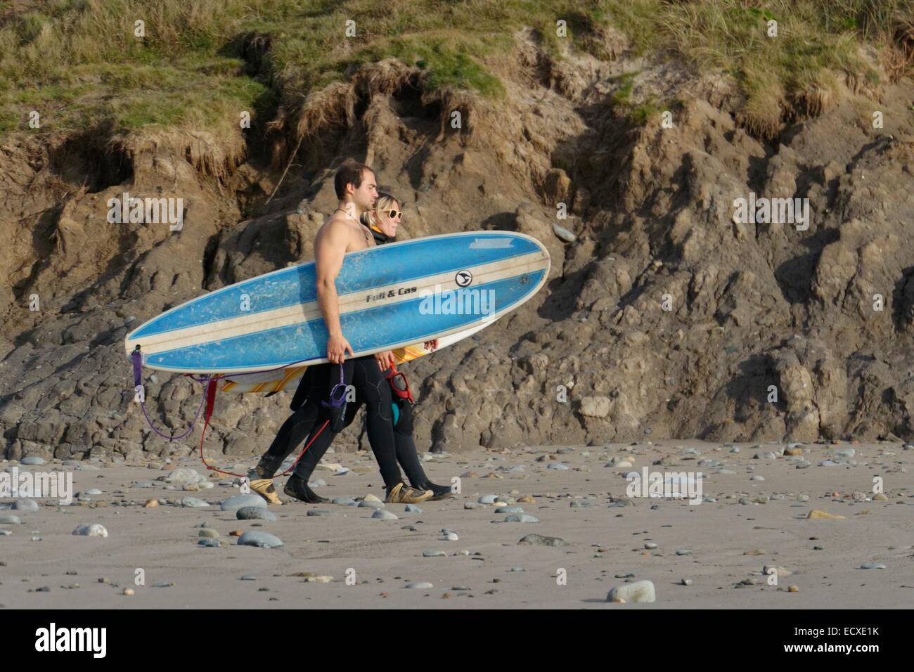 Good conditions for surfing in North Wales. A Couple carry their long ...