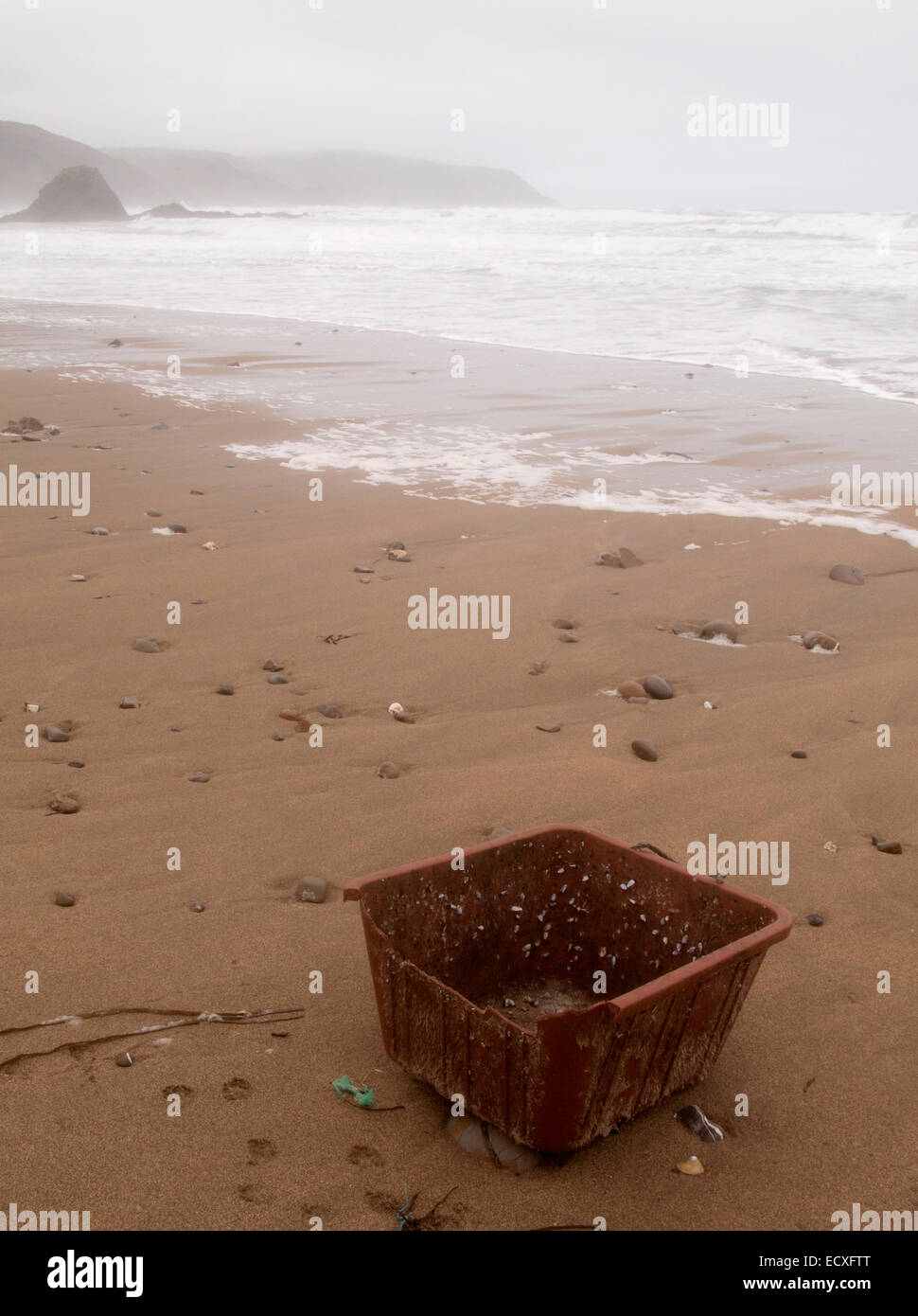 Old plastic container washed up on the beach after a winter storm ...