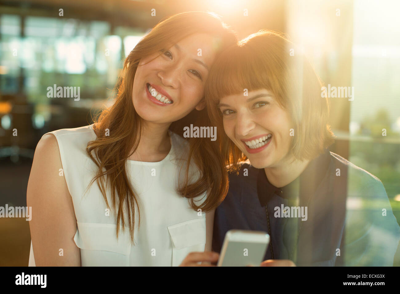 Businesswomen using cell phone in office Stock Photo - Alamy