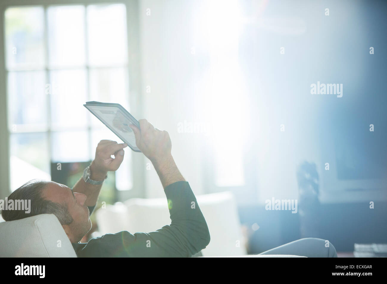 Mature man sitting couch living room using tablet hi-res stock ...