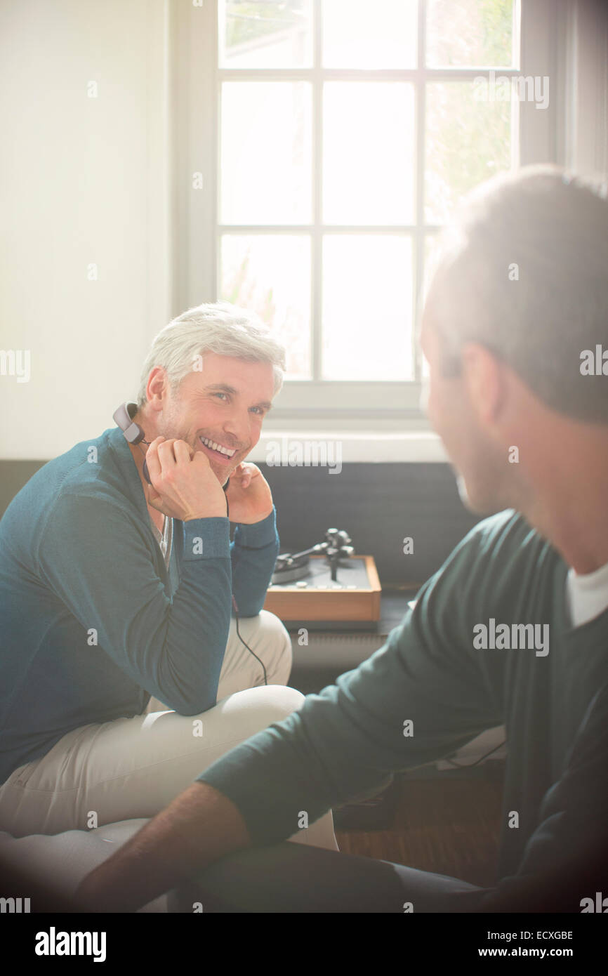 Men relaxing together in living room Stock Photo - Alamy