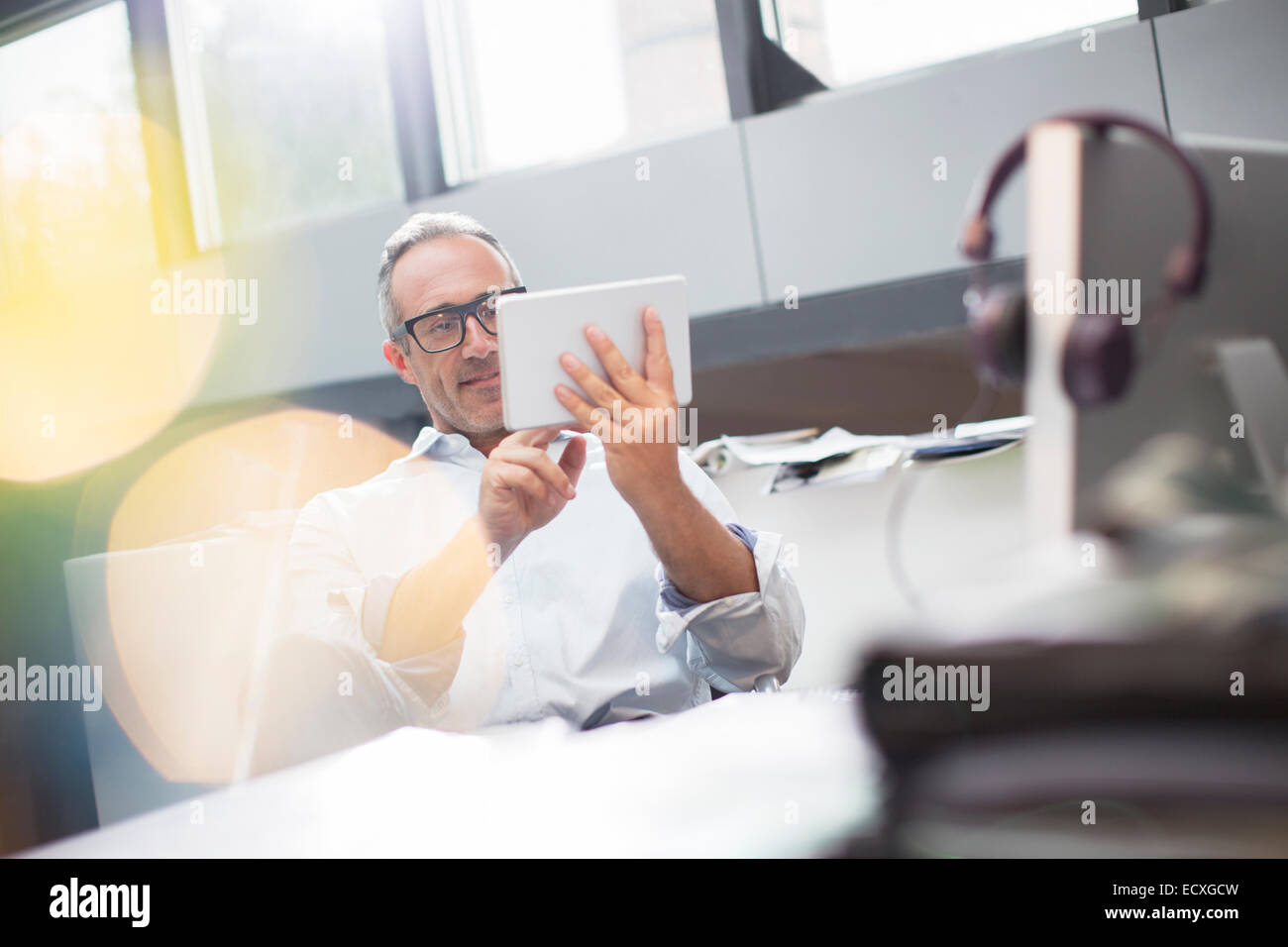 Businessman using digital tablet at office desk Stock Photo - Alamy