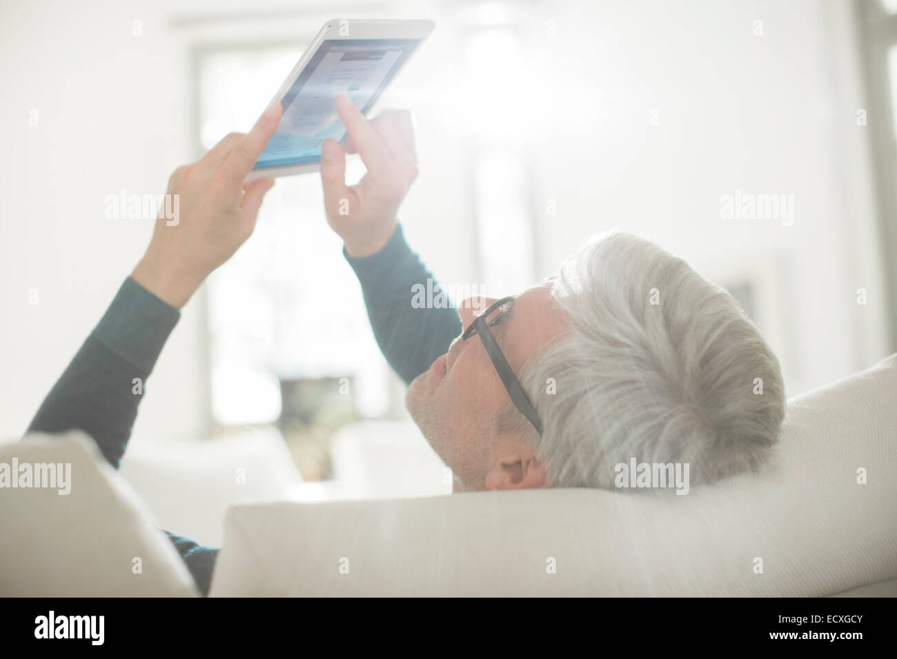 Mature man sitting couch living room using tablet hi-res stock ...