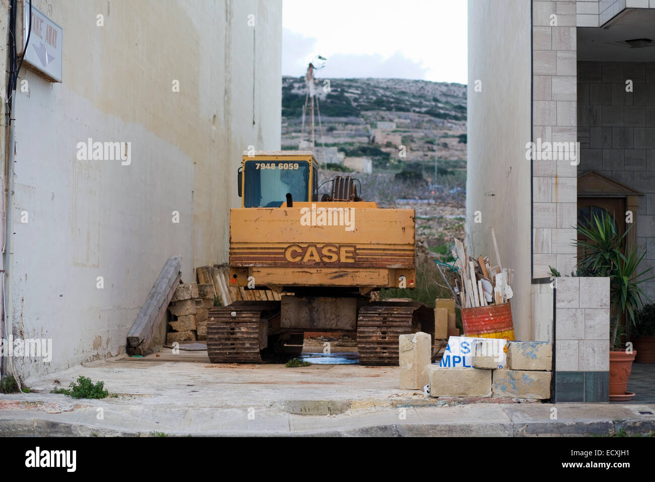 Case Digger in between two houses clearing site for building Stock ...