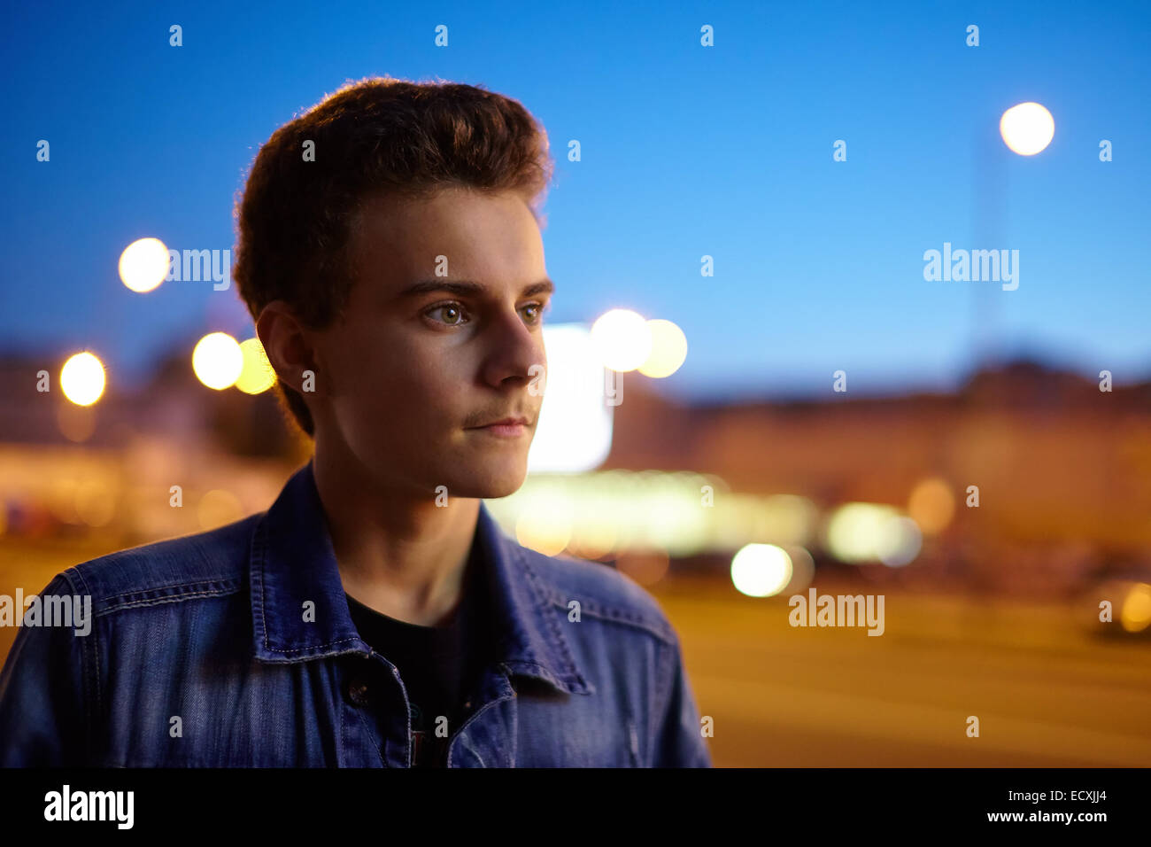 Closeup of a teenage boy in an urban environment at night Stock Photo ...