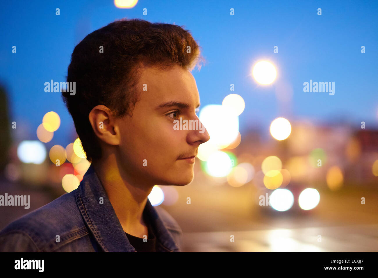Closeup of a teenage boy in an urban environment at night Stock Photo ...
