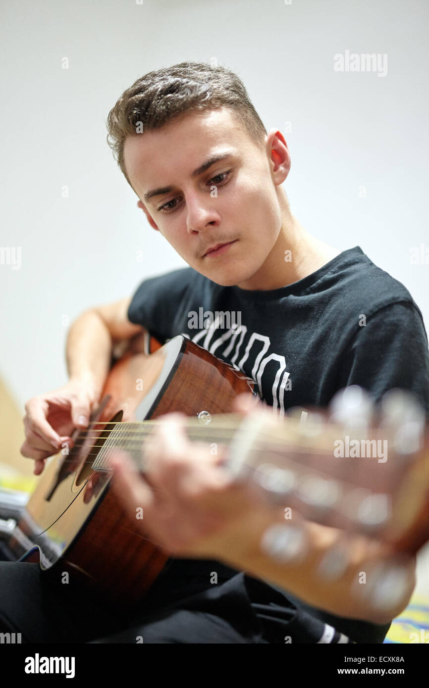 Closeup of a teenage boy playing his acoustic guitar Stock Photo - Alamy