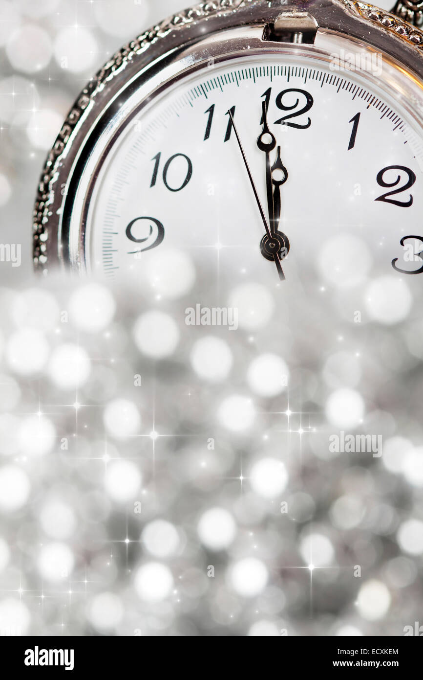 New Year's at midnight - Old clock with fireworks and holiday lights ...