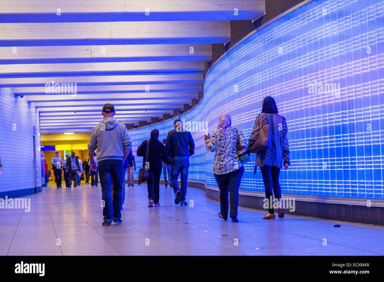 Passengers in an underground passage with a wall of lights Stock Photo ...