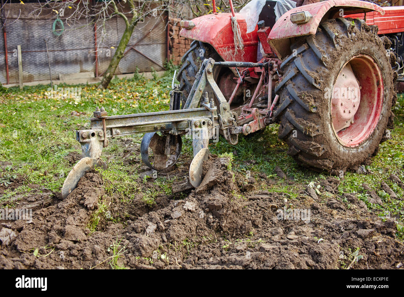 Image from the back of a tractor plowing the land, focus is on plow ...