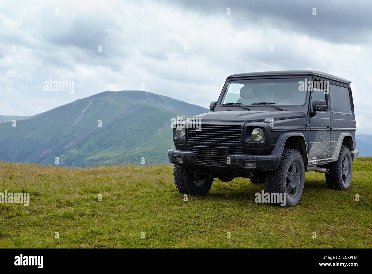 Off road car in a mountain environment on a meadow Stock Photo - Alamy
