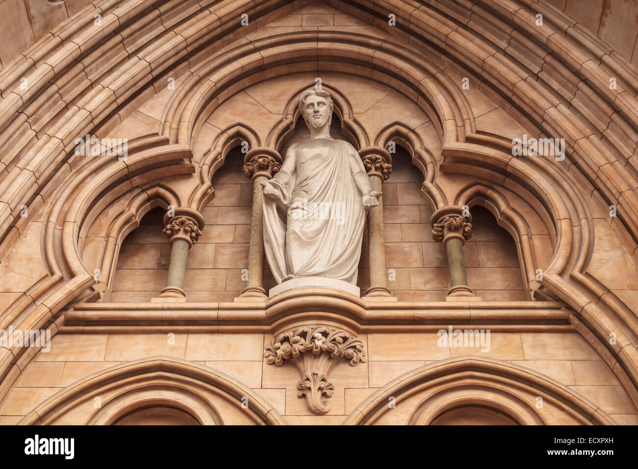 A carved statue stands overhead, welcoming visitors to the entrance of ...