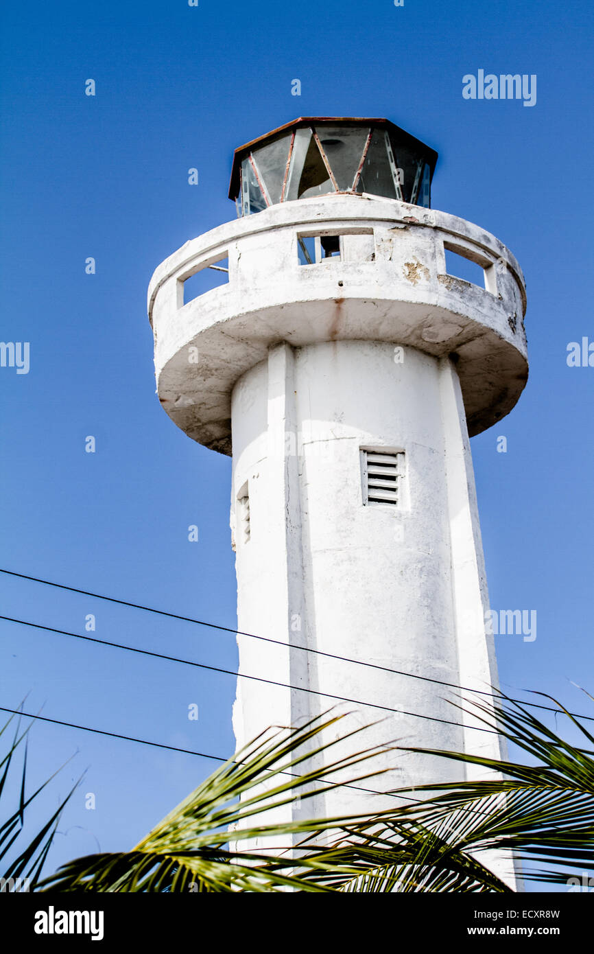 An old white beacon lighthouse from a tropical island with palms Stock ...