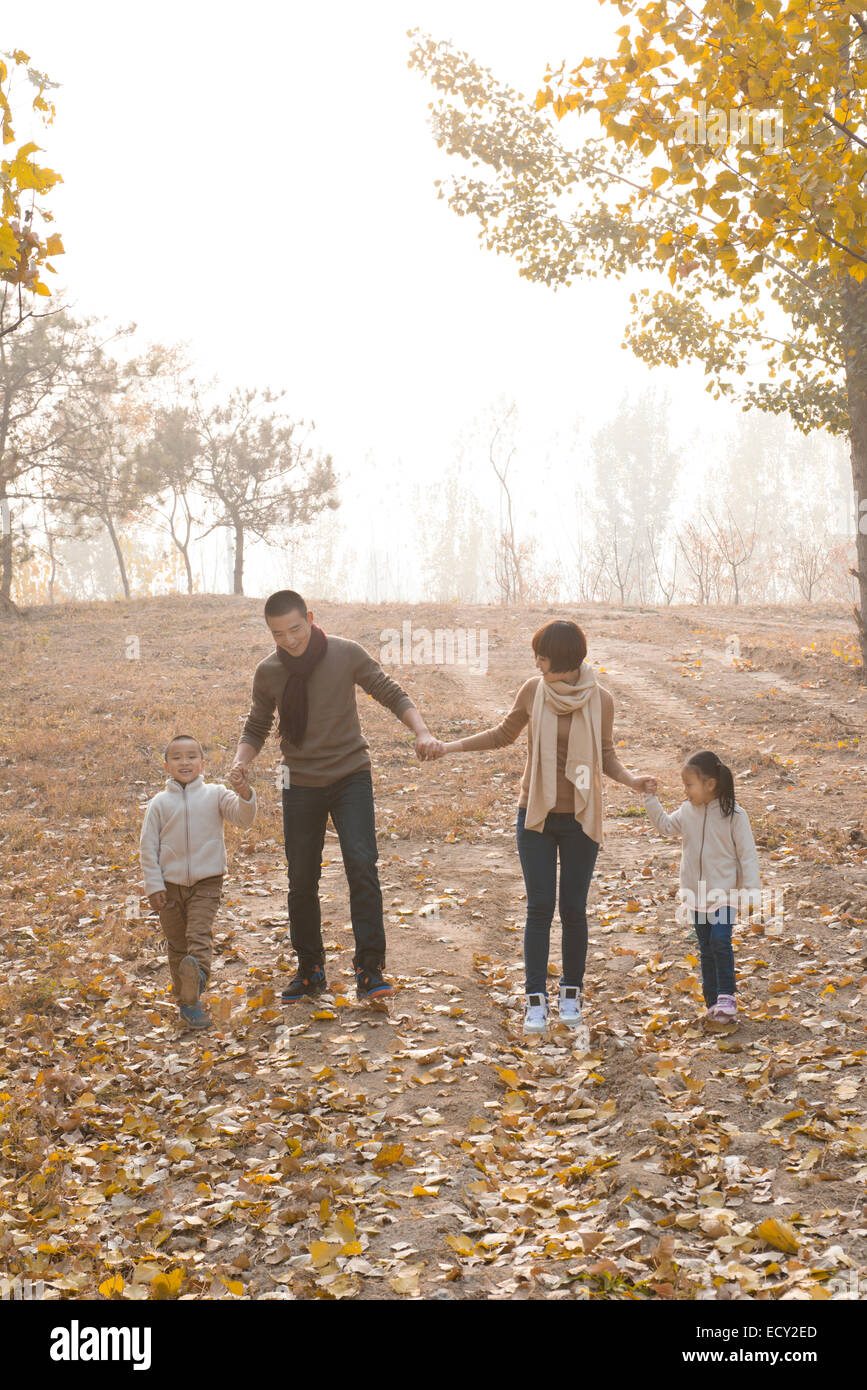 Family with two children walking at park Stock Photo - Alamy