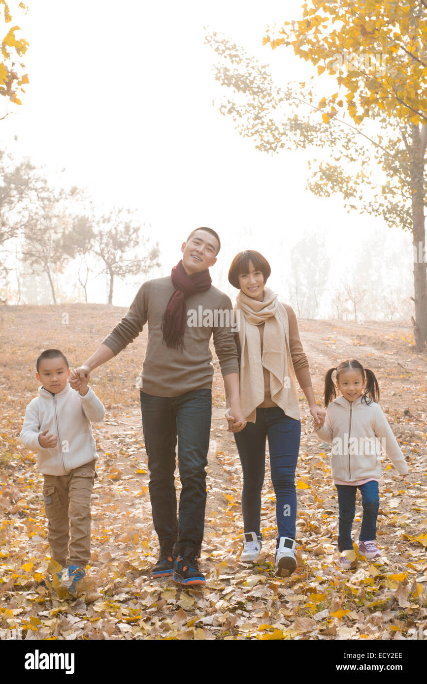 Family with two children walking at park Stock Photo - Alamy