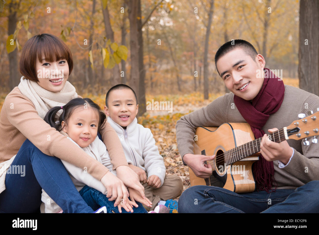 Family with two children at park Stock Photo - Alamy