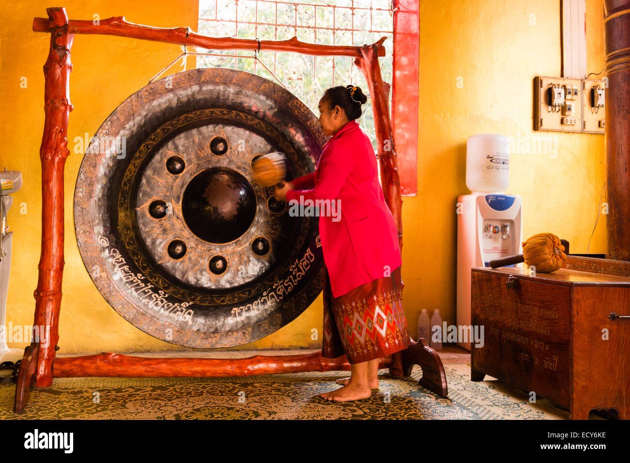 Monk using a Gong during the prayer, Wat Si Muang, Vientiane, Vientiane ...