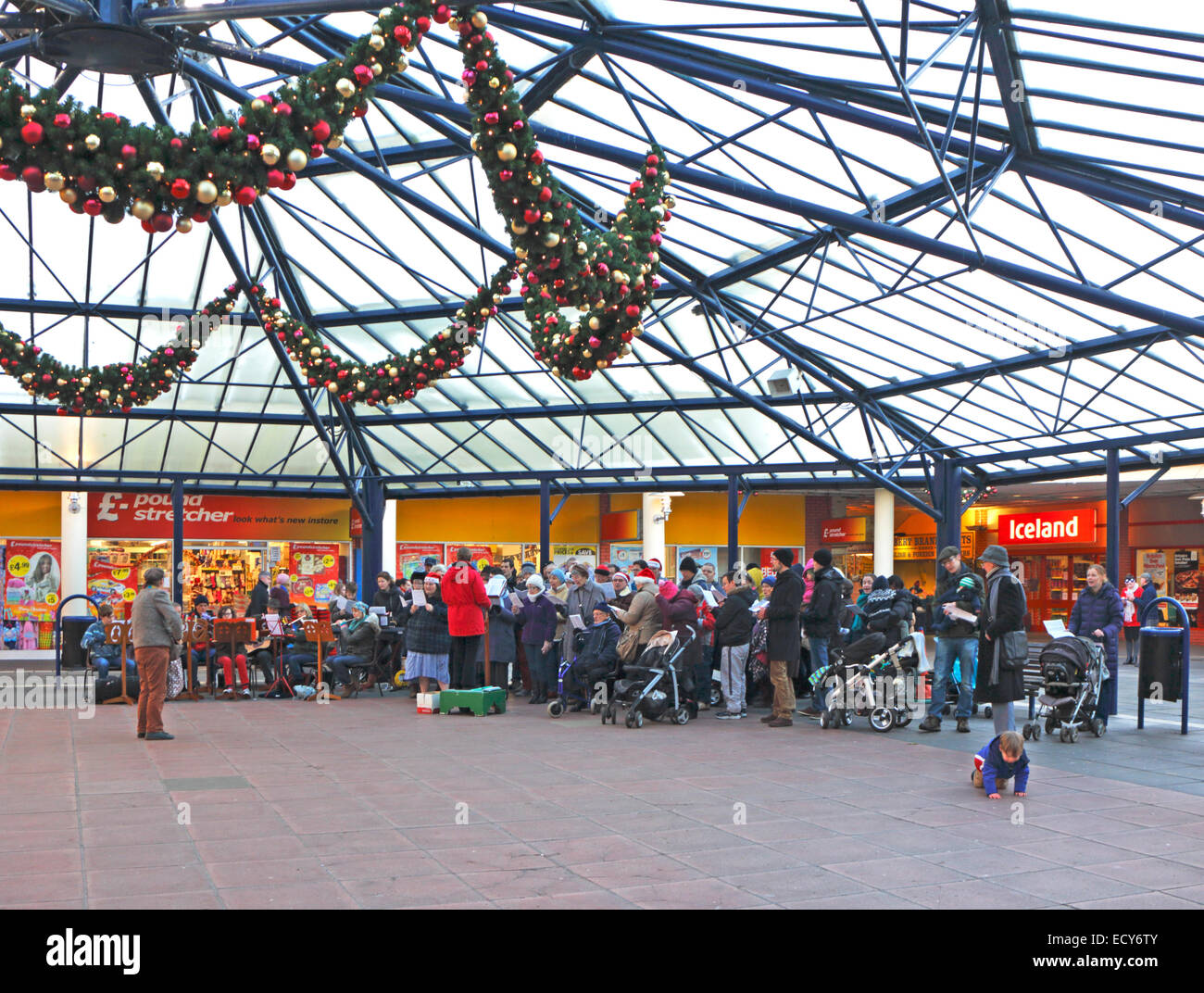 A group of carol singers and a band in Anglia Square shopping centre ...