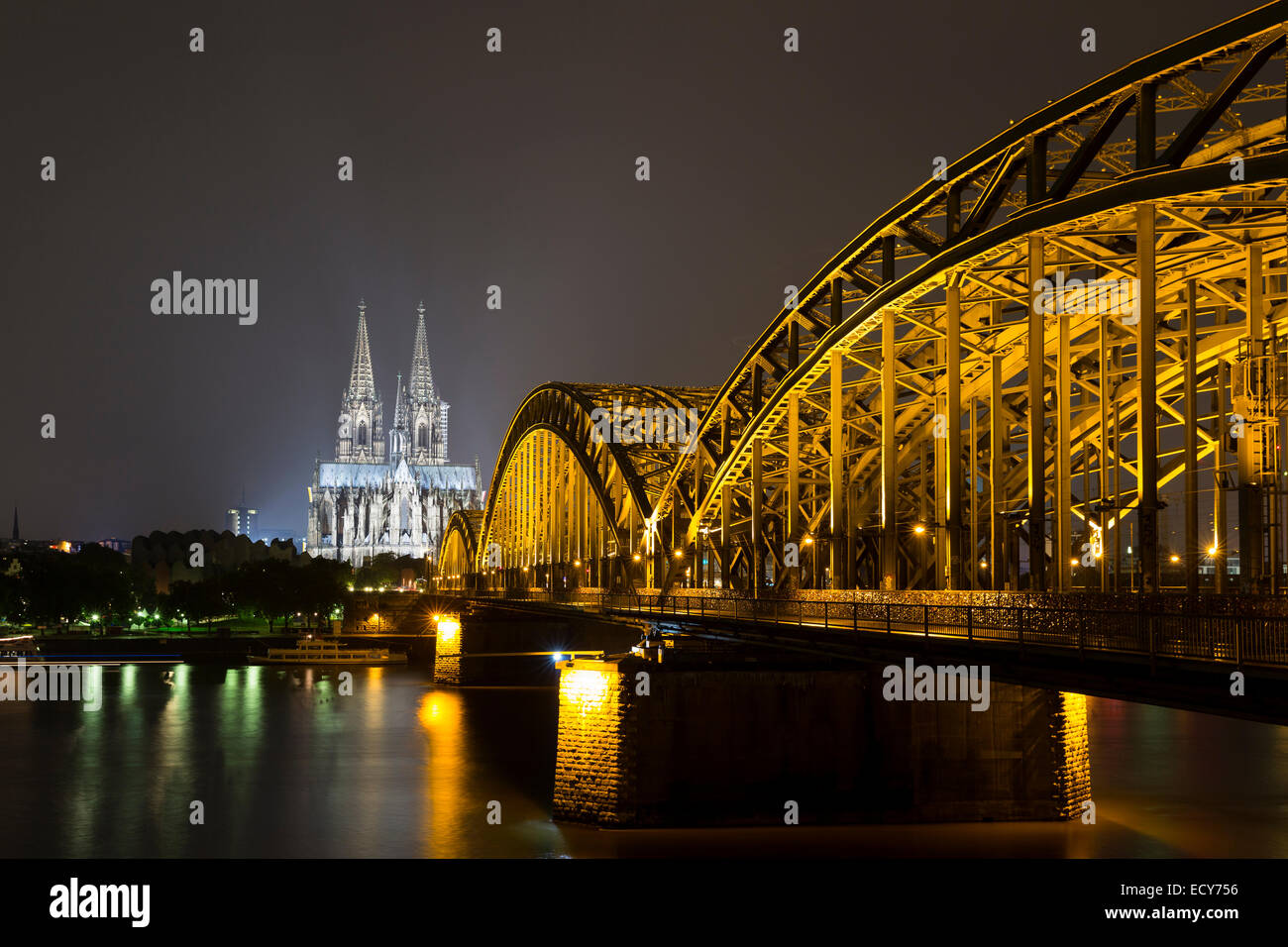 The illuminated Cologne Cathedral and Hohenzollern Bridge at night with ...
