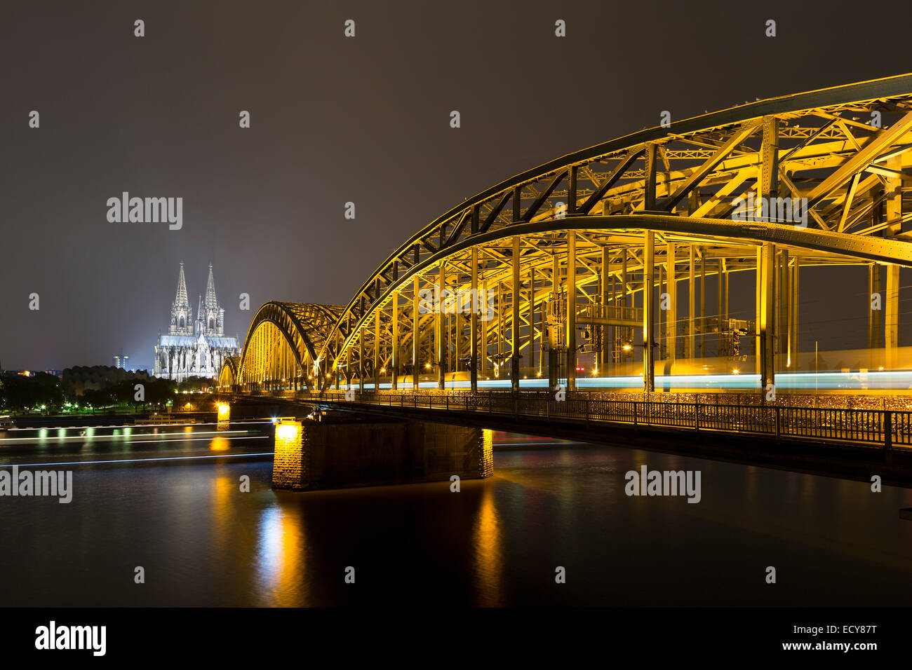 The illuminated Cologne Cathedral and Hohenzollern Bridge at night with ...