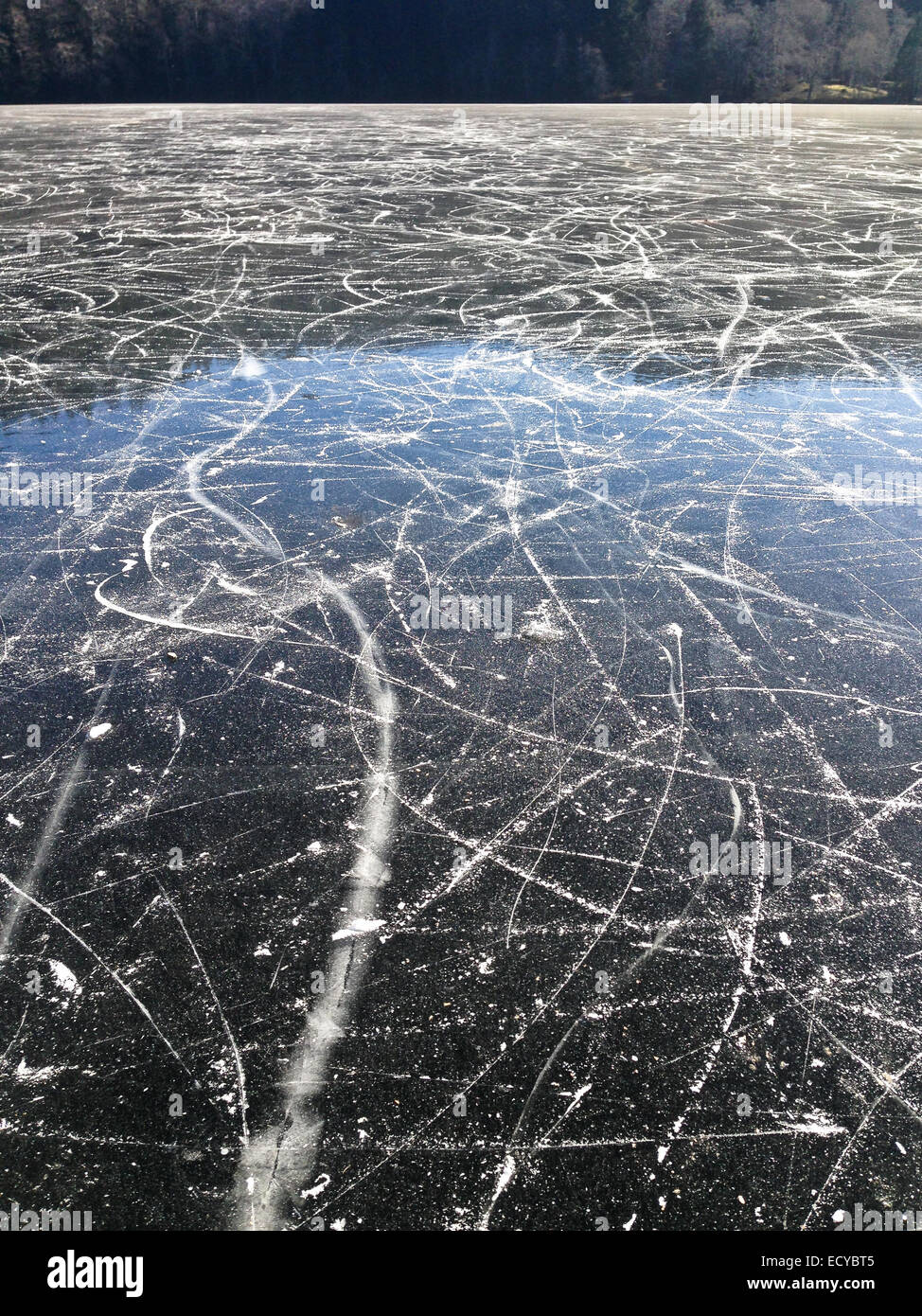 Lines on ice covering frozen lake Stock Photo - Alamy