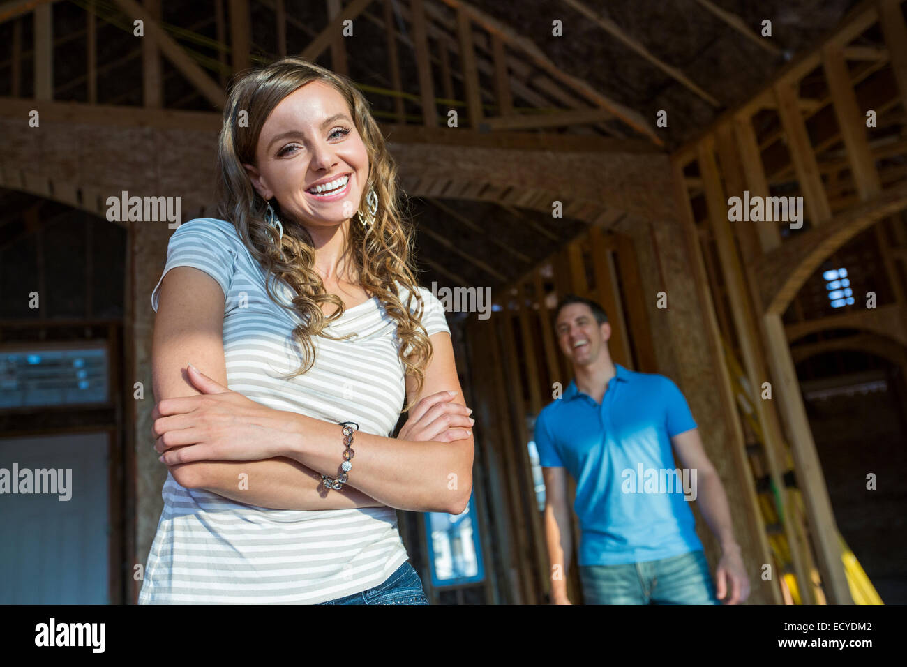 Caucasian woman smiling in house under construction Stock Photo - Alamy