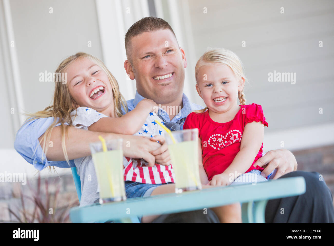Caucasian father and daughters laughing on porch Stock Photo - Alamy