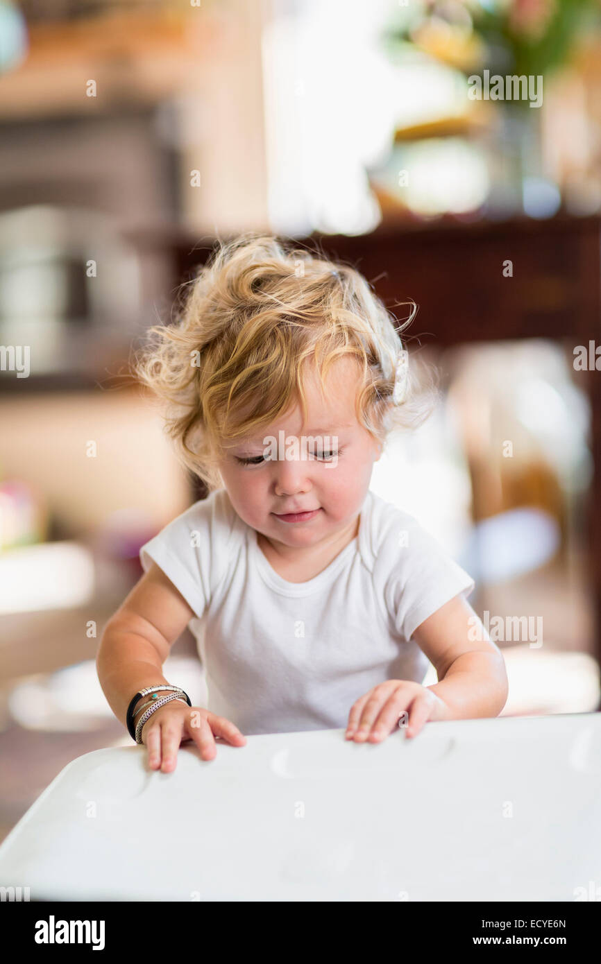 Curious Caucasian baby boy opening container Stock Photo - Alamy