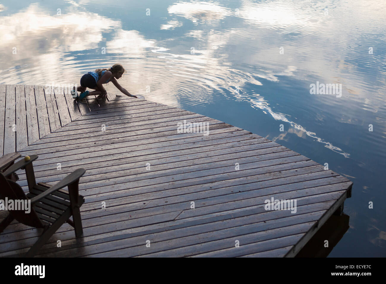 Caucasian girl on wooden deck making ripples in lake Stock Photo - Alamy