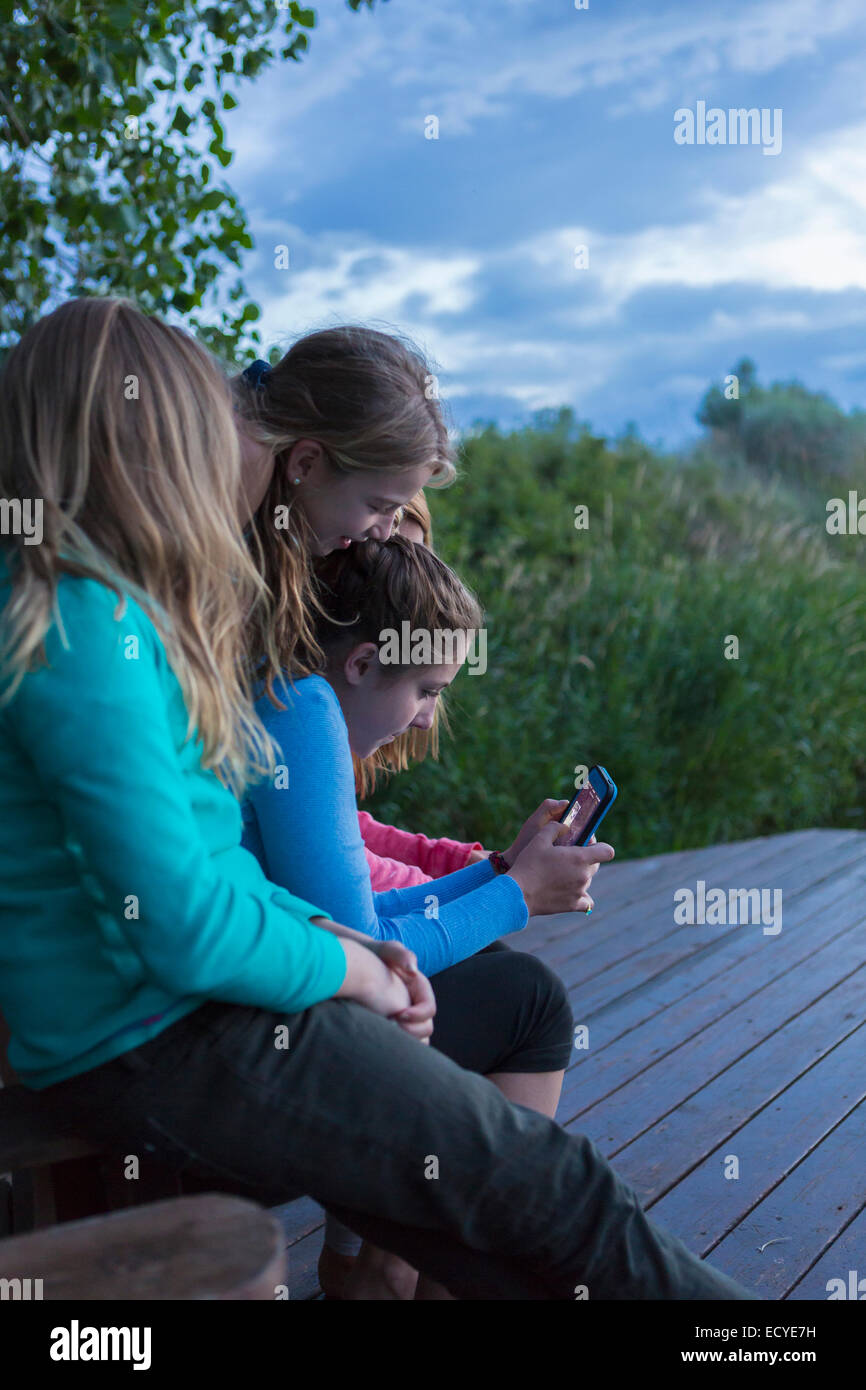 Children using cell phone together outdoors Stock Photo - Alamy