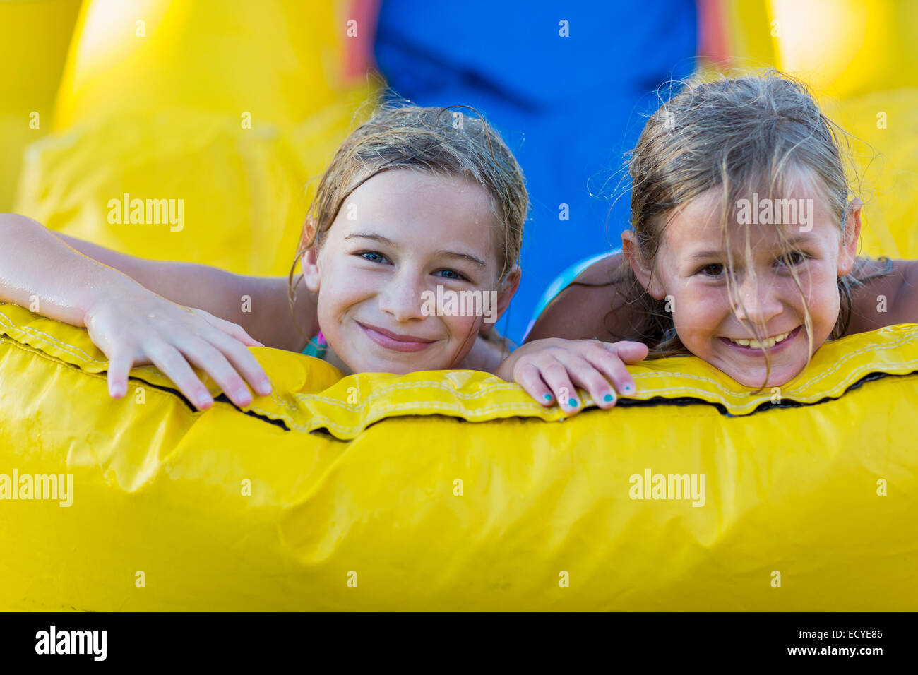 Caucasian girls playing together on inflatable castle Stock Photo - Alamy
