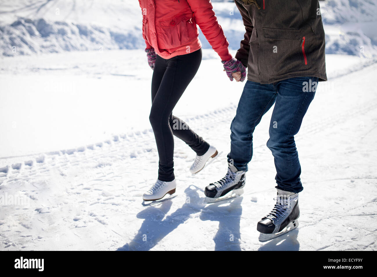 Caucasian couple ice skating on snowy frozen lake Stock Photo - Alamy