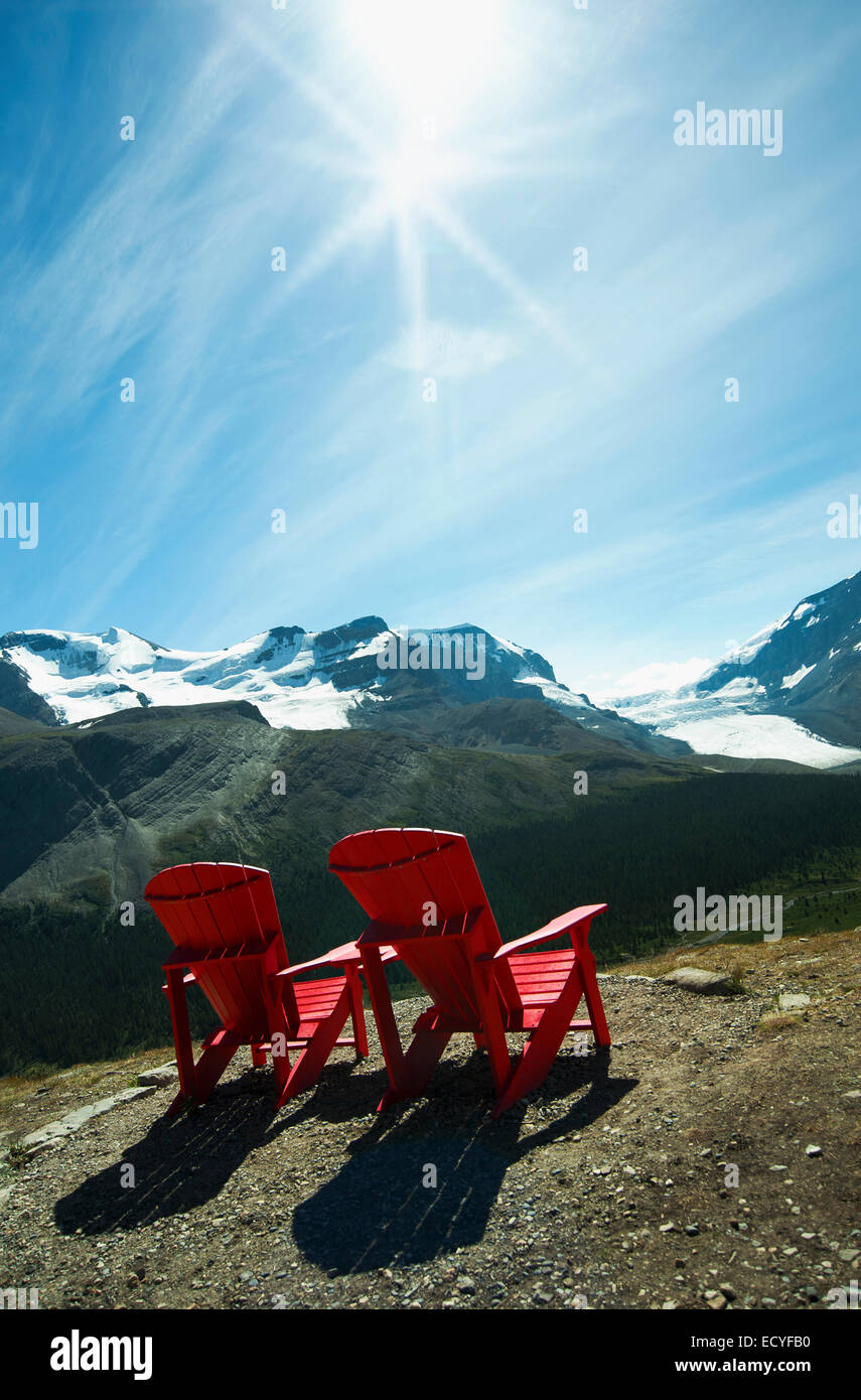 Red lawn chairs overlooking scenic mountain landscape Stock Photo - Alamy