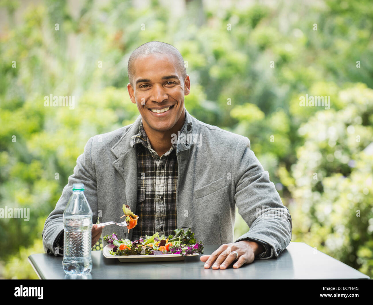 Black man eating lunch in urban park Stock Photo - Alamy