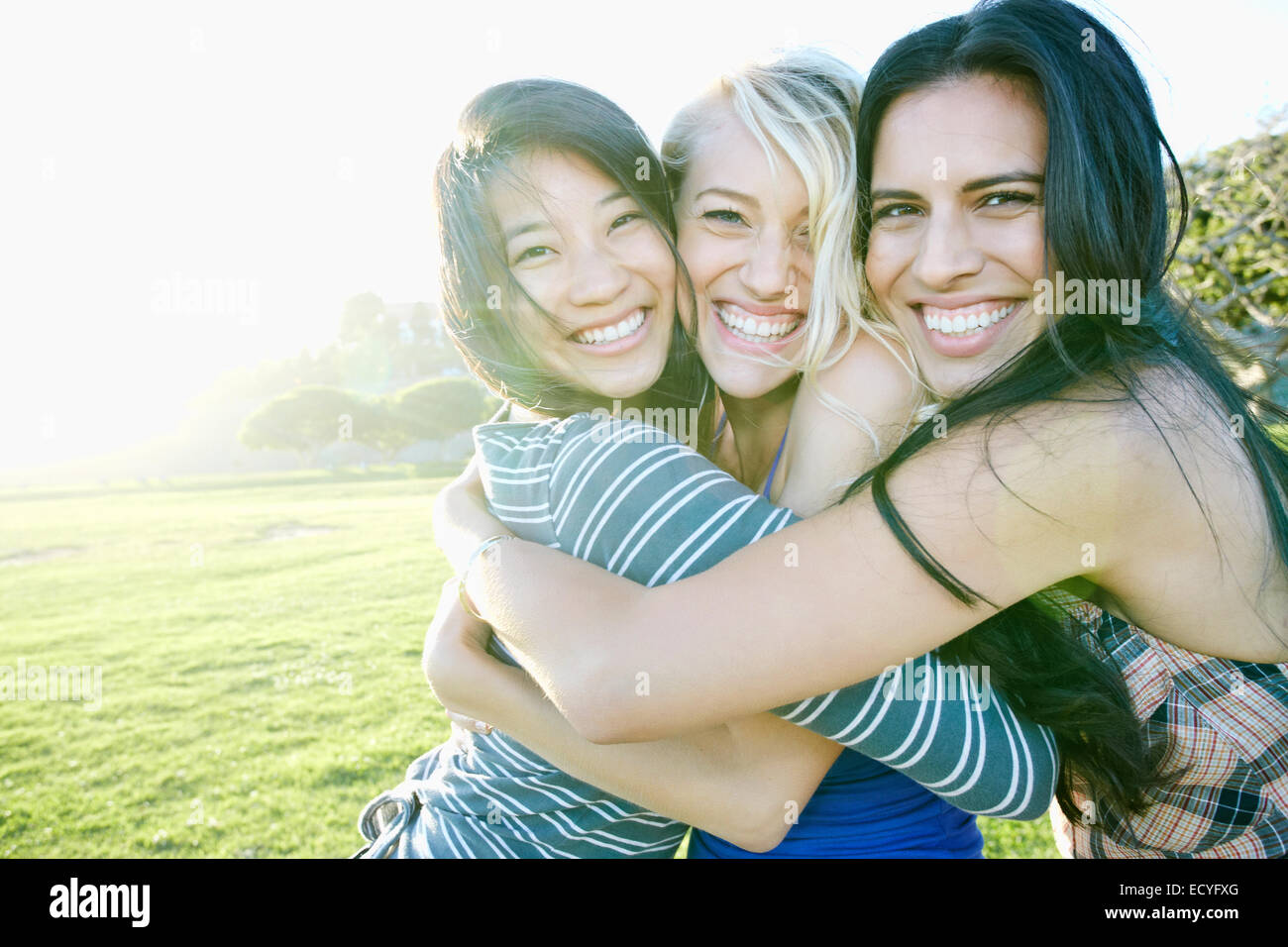 Smiling women hugging outdoors Stock Photo - Alamy