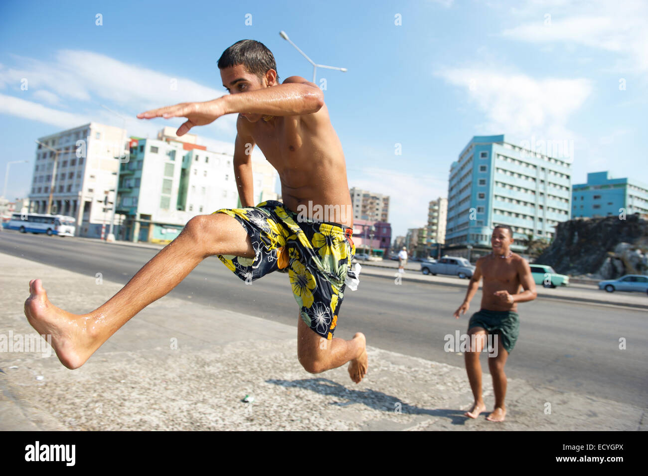 HAVANA, CUBA - MAY 23, 2011: Young Cubans run to jump into the sea at a ...