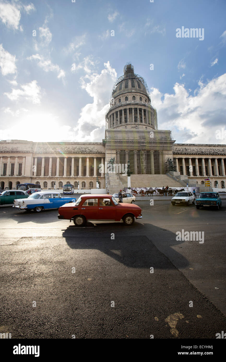 Classic cars driving next to the National Capitol Building in Havana ...
