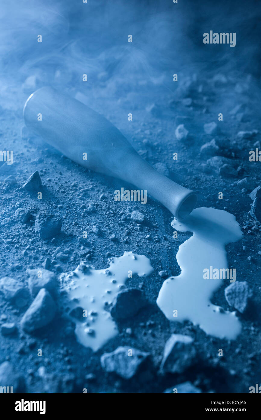 Upset bottle spilling white liquid at night Stock Photo - Alamy