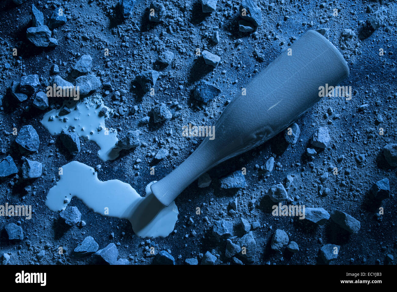 Upset bottle spilling white liquid at night Stock Photo - Alamy