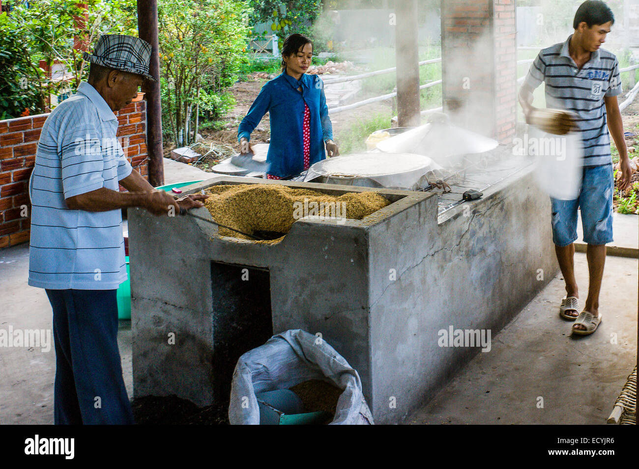 Vietnamese family working in their small home factory making rice paper ...