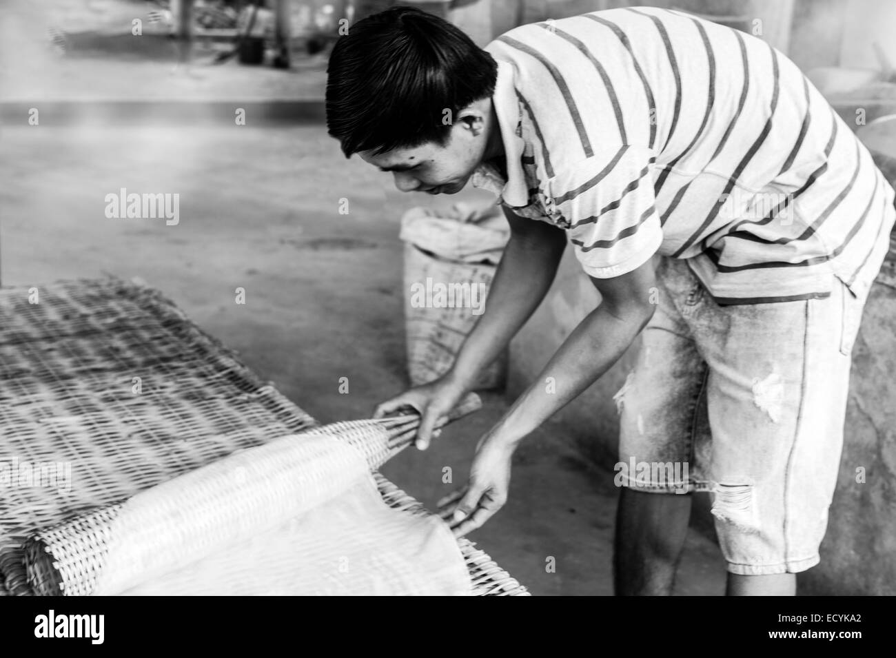 Vietnamese family working in their small home factory making rice paper ...
