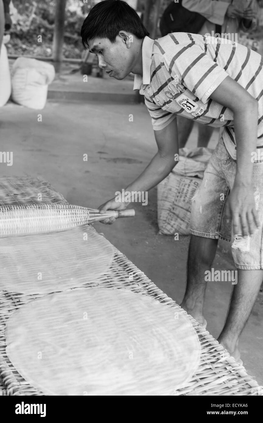 Vietnamese family working in their small home factory making rice paper ...