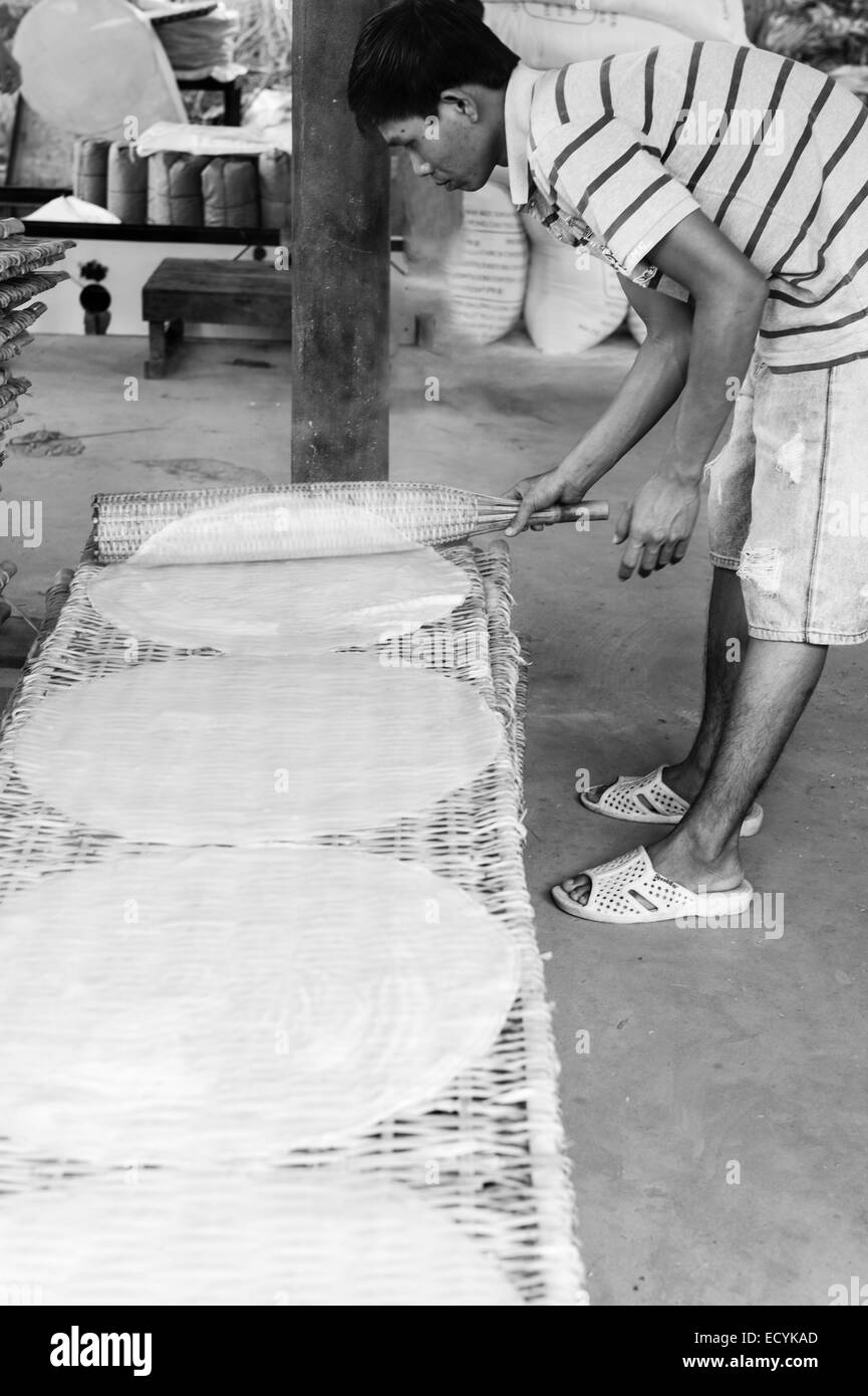 Vietnamese family working in their small home factory making rice paper ...