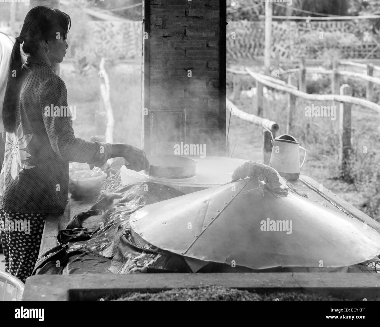 Vietnamese family working in their small home factory making rice paper ...